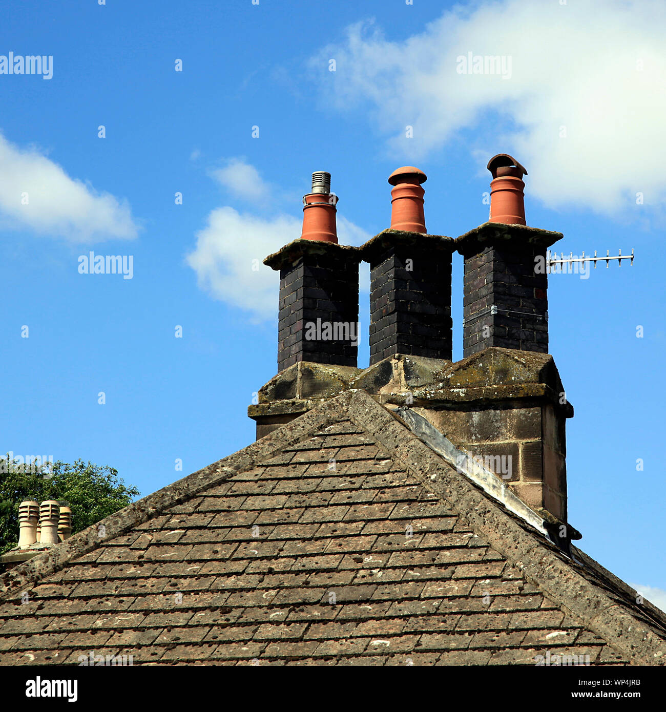 Triple chimney stack on house roof Stock Photo - Alamy