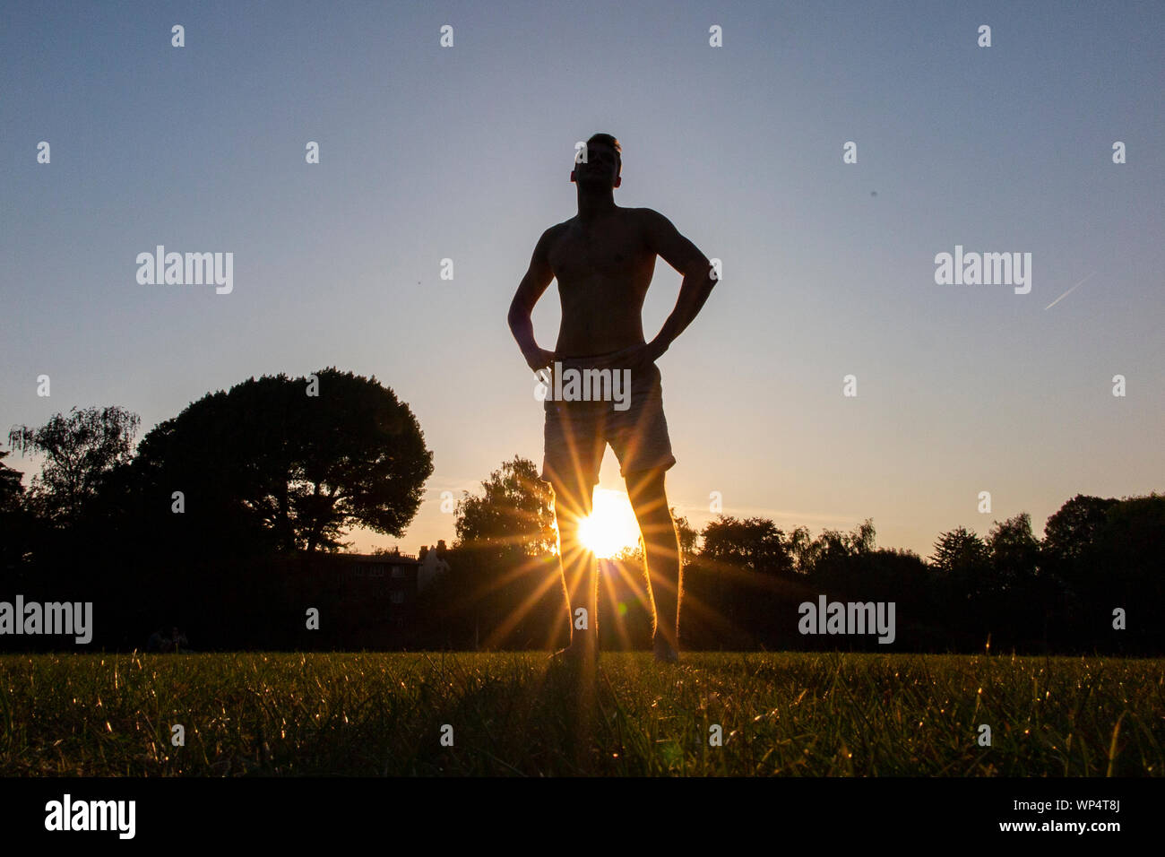 A boy catching and passing a rugby ball on a summer's day in a park ...