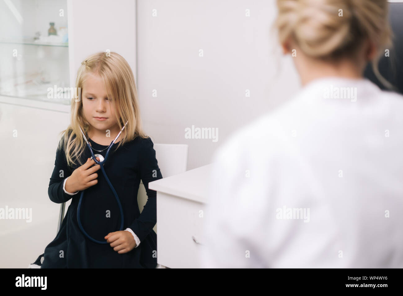 Portrait of little girl listening breathing and heartbeat through ...