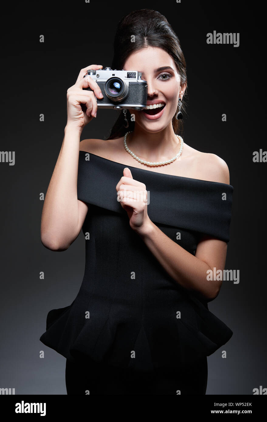 Retro shot: the beautiful young woman photographing by old film camera ...