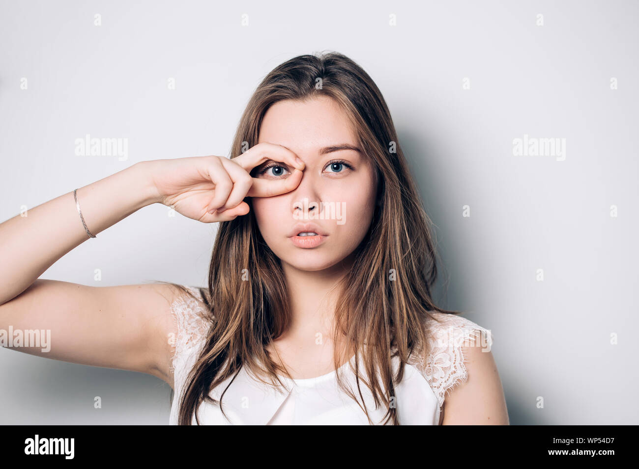 Beautiful brunette woman showing dancing gesture on white background ...