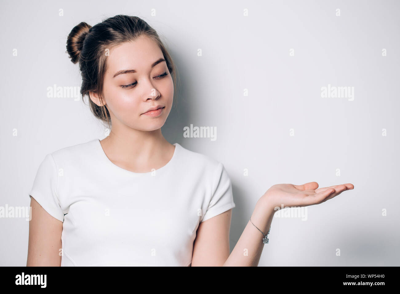 Pretty cheerful woman gesturing with fingers and showing palm ...