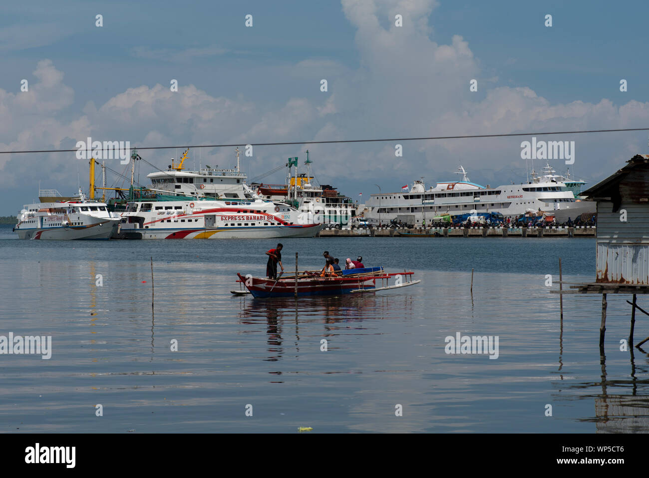 Canoe passing ferries, Sorong, West Papua, Indonesia Stock Photo - Alamy