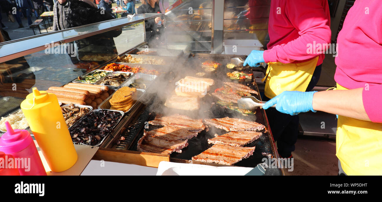 cook with a latex glove while cooking sausages in an alfresco street ...