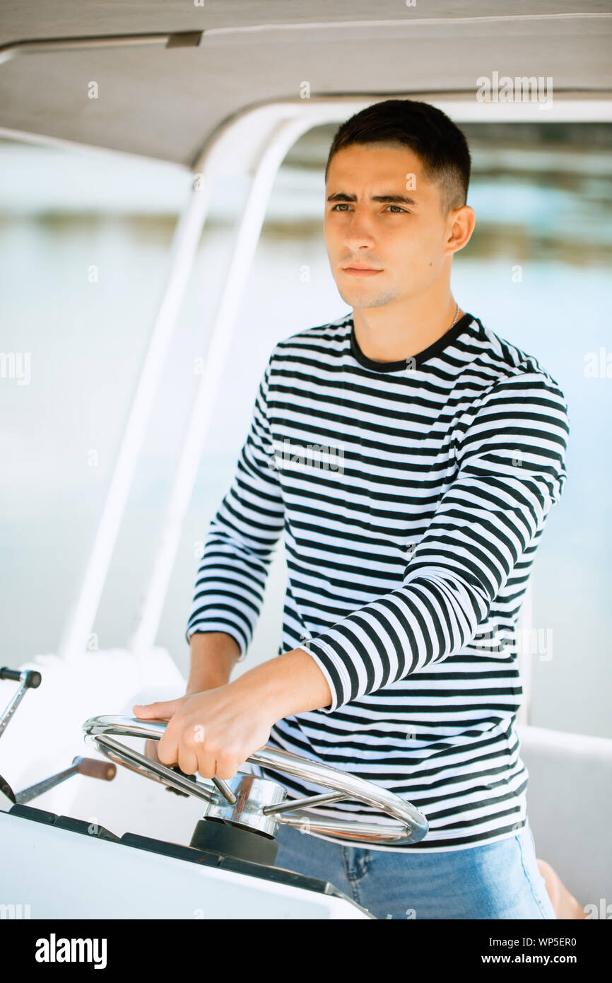 Man driving boat handsome hi-res stock photography and images - Alamy