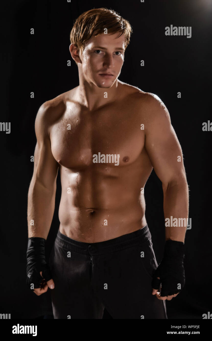 Side view of muscular man boxing on black background Stock Photo - Alamy