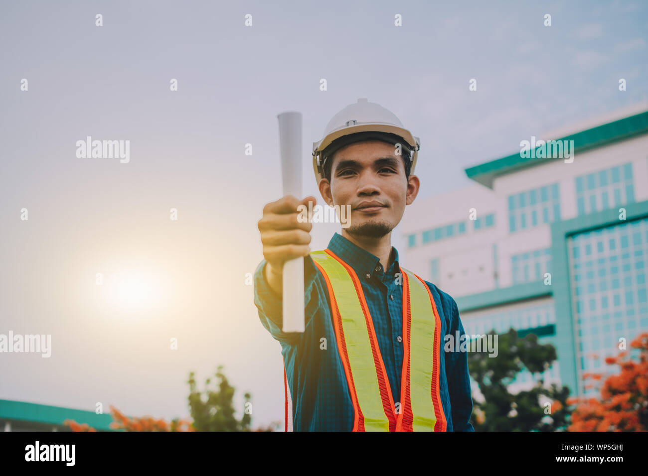 Engineer holding paper factory plant background Stock Photo - Alamy