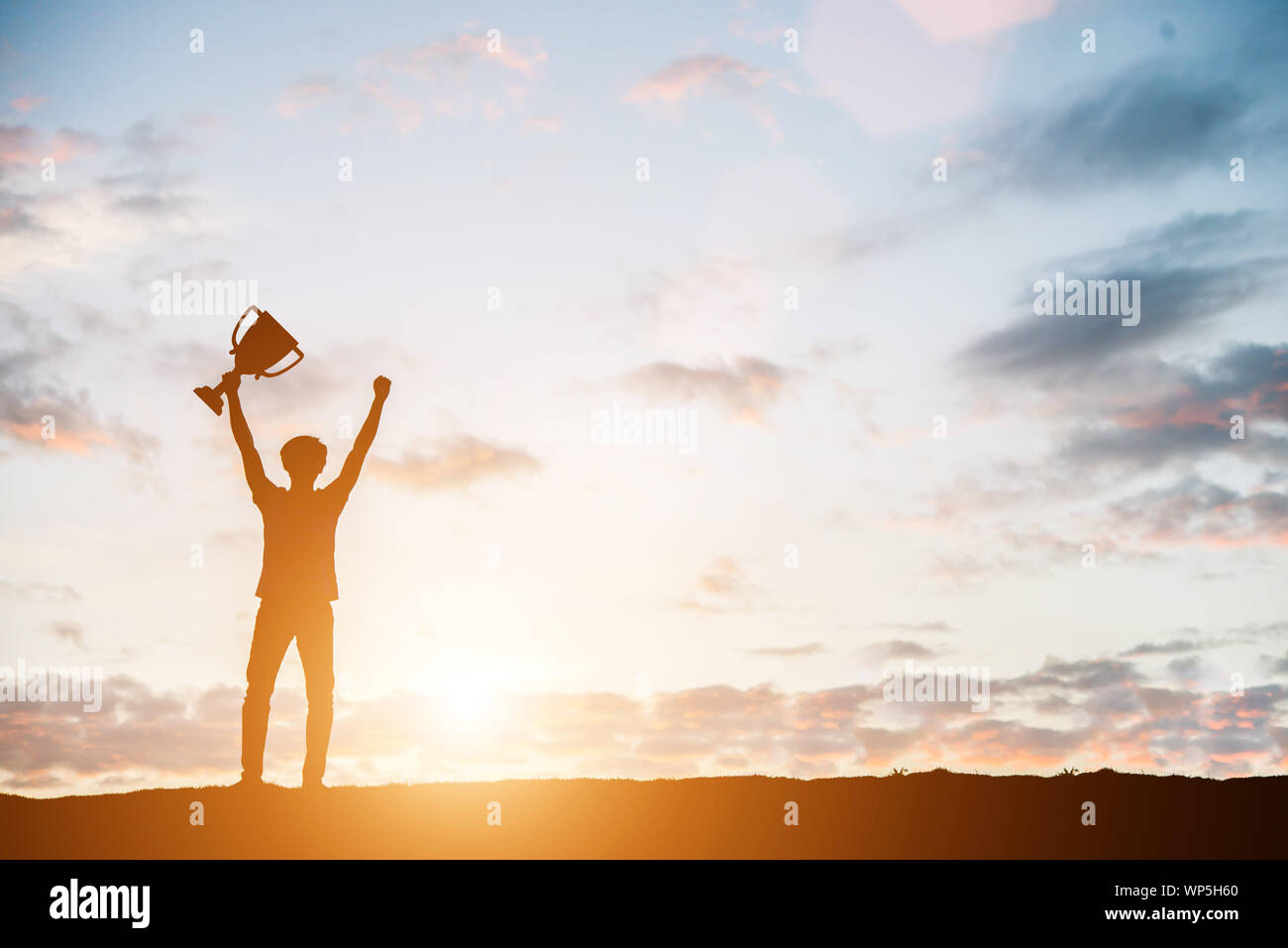 Silhouettes of man won a trophy, achieved with his work Stock Photo - Alamy