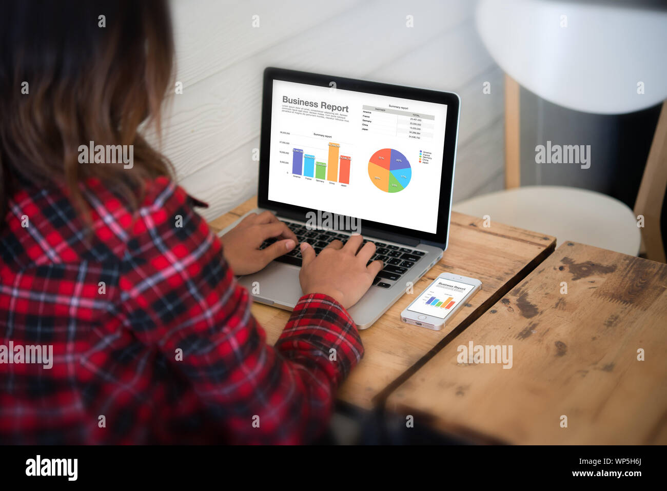 Close-up rear view of young business woman working in office, typing ...