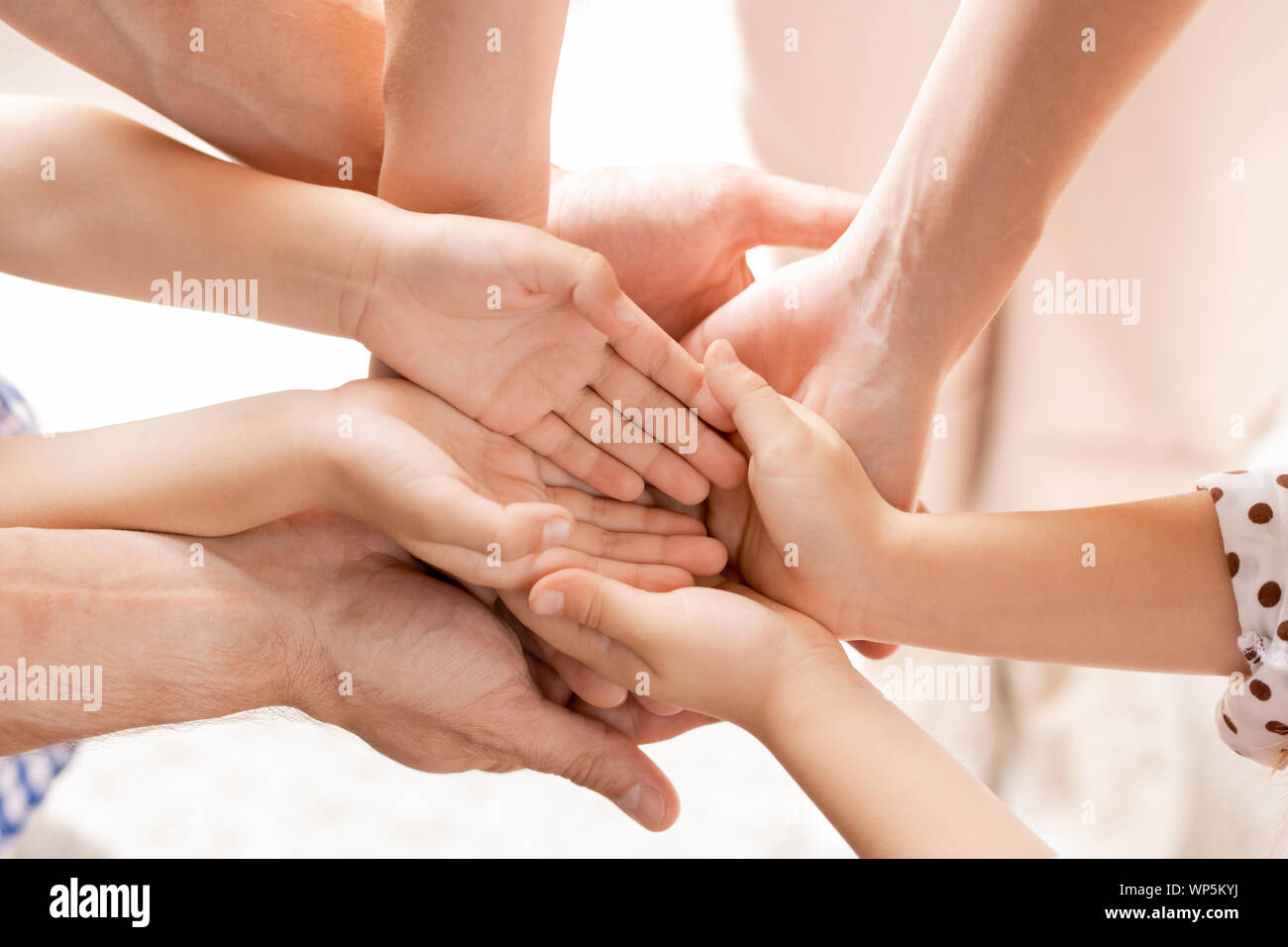 Top view of open hands of little kids and their young parents making ...
