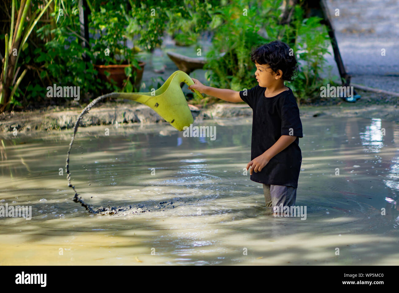 1 Asian boy playing with mud in a fun place inside a mud pit built for ...