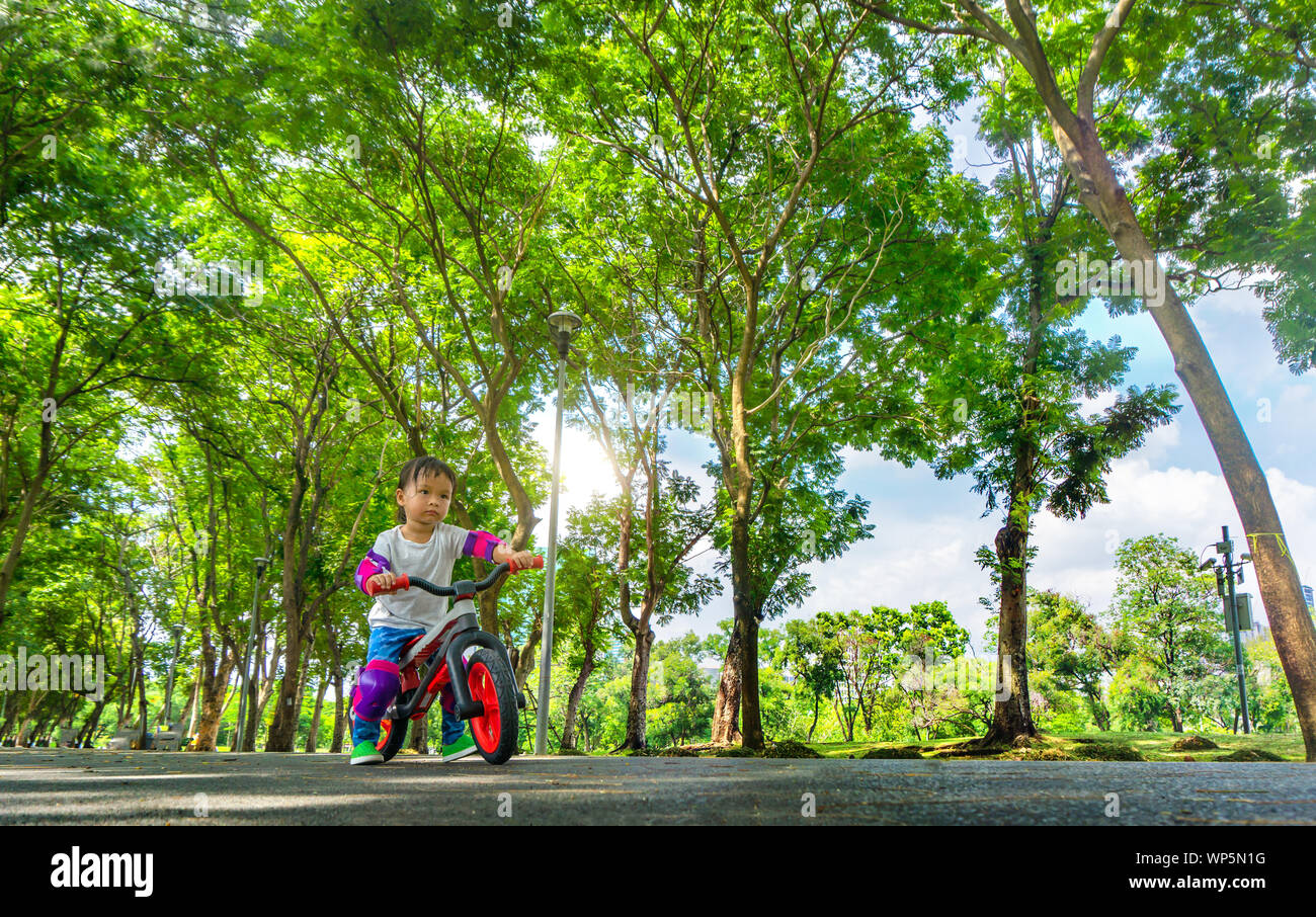 Asian kid first day play balance bike. Little boy learning to ride with bicycle Stock Photo - Alamy