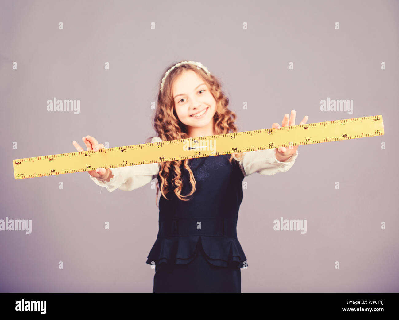 Kid school uniform hold ruler. Pupil cute girl with big ruler. Geometry ...