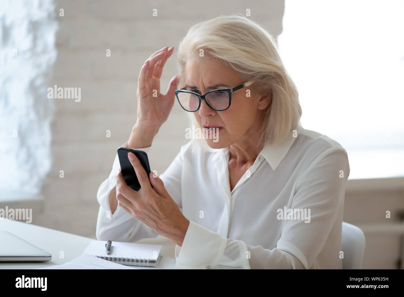Frustrated woman hold cellphone having device troubles Stock Photo - Alamy