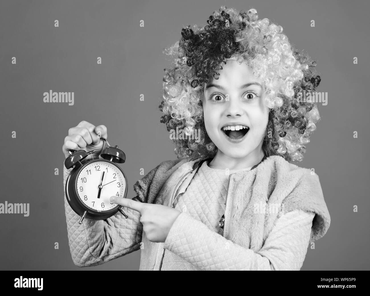 Focusing on accuracy. Happy small child pointing at alarm clock. Little ...