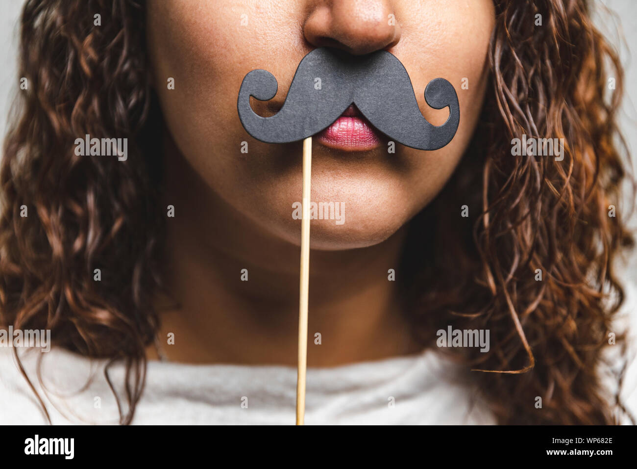 Close up portrait head shot of Young girl wearing fake mustaches - Girl holding funny mustache ...