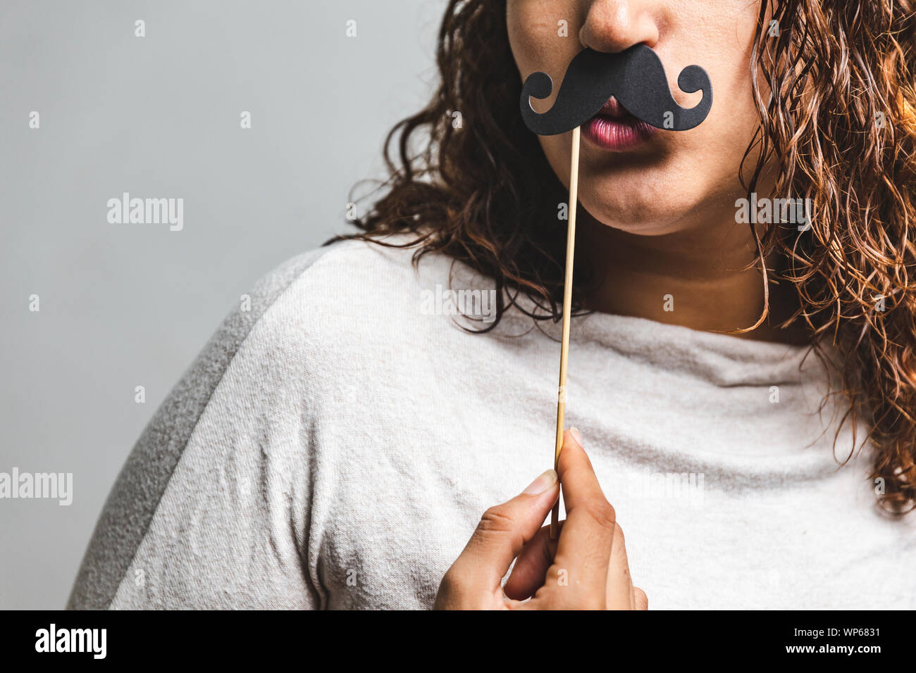 Close up portrait head shot of Young girl wearing fake mustaches - Girl holding funny mustache ...