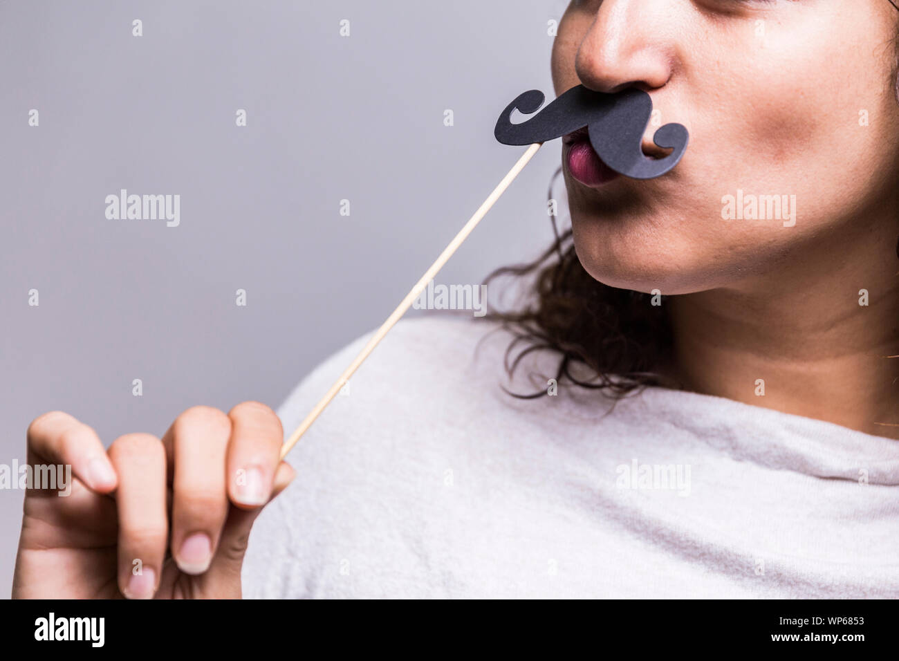 Close up portrait head shot of Young girl wearing fake mustaches - Girl holding funny mustache ...