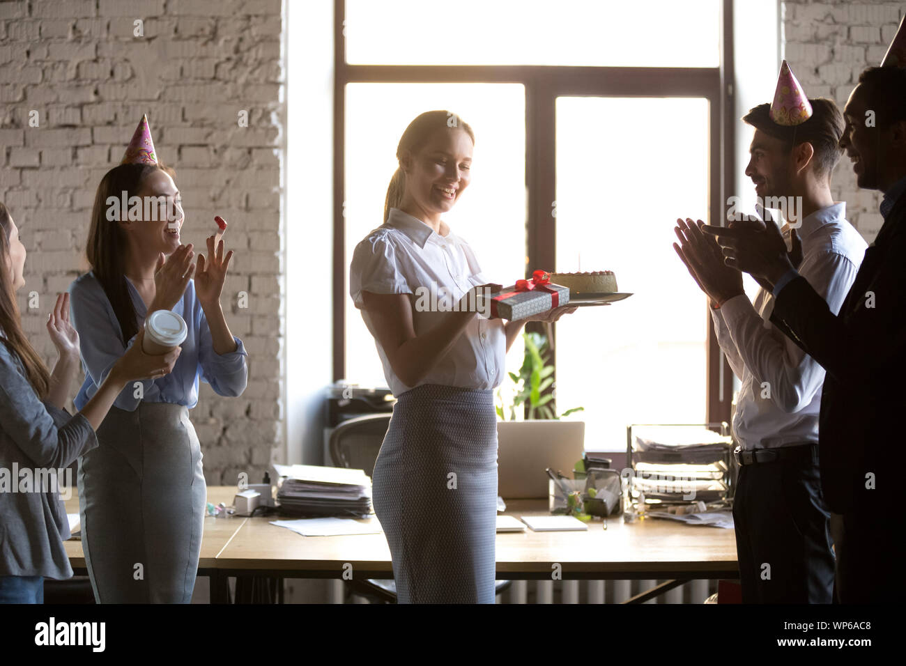 Happy diverse employees congratulating colleague with birthday, party ...