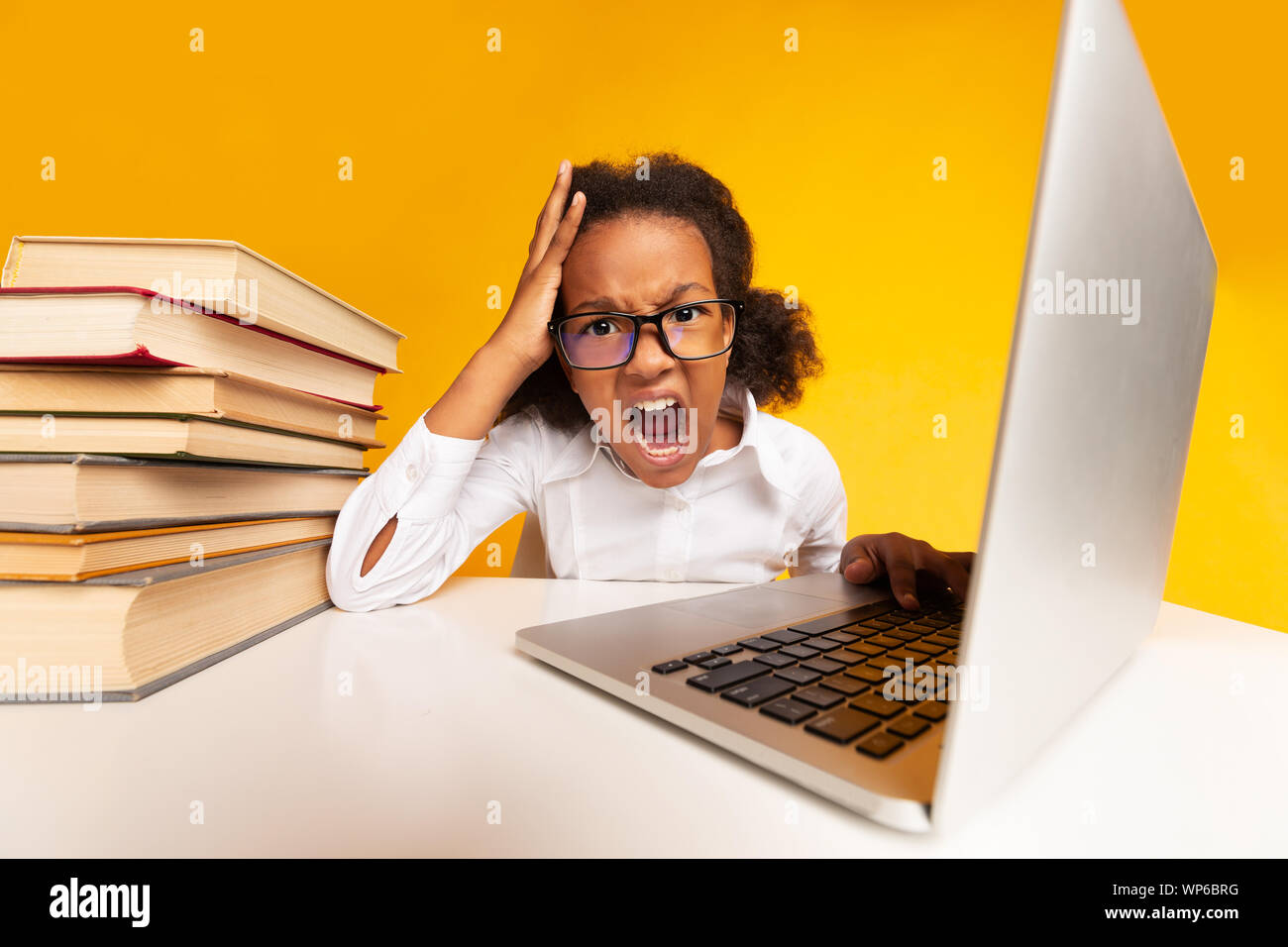 Elementary Student Girl Sitting At Laptop And Screaming In Studio Stock ...