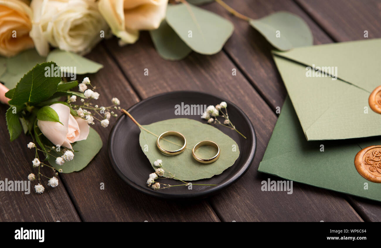 Creative Wedding rings composition on small plate on wood Stock Photo ...