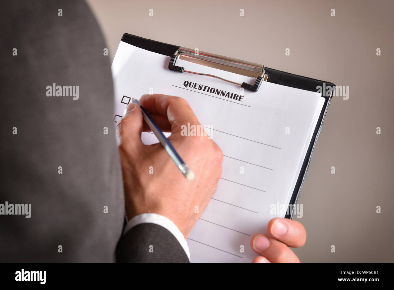 Man in suit showing a questionnaire with sheets in a folder and a ...