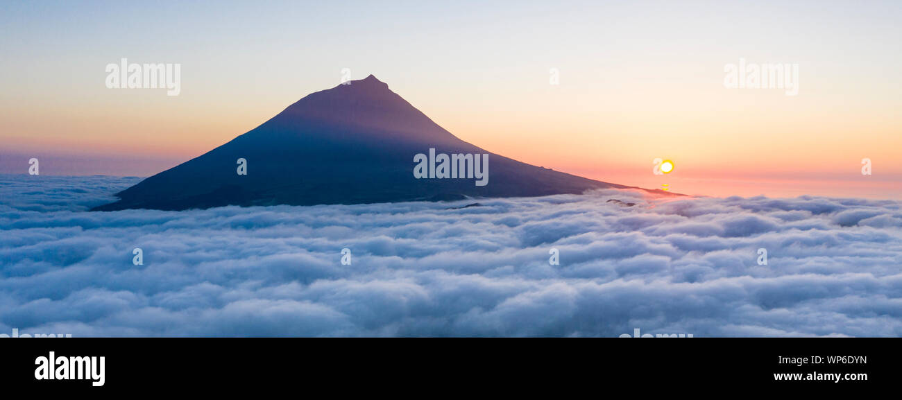 Aerial image with magical sunset over a low cloud layer covering Pico ...