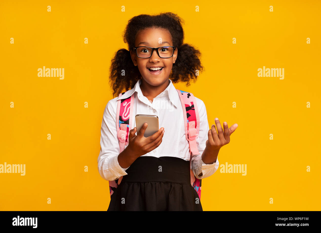 Happy African American Schoolgirl Browsing On Cellphone, Yellow ...