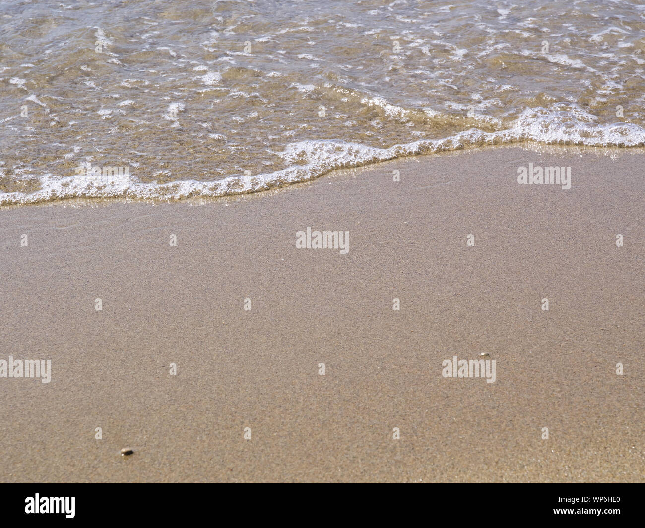 Beach close up on sand and sea water Stock Photo - Alamy