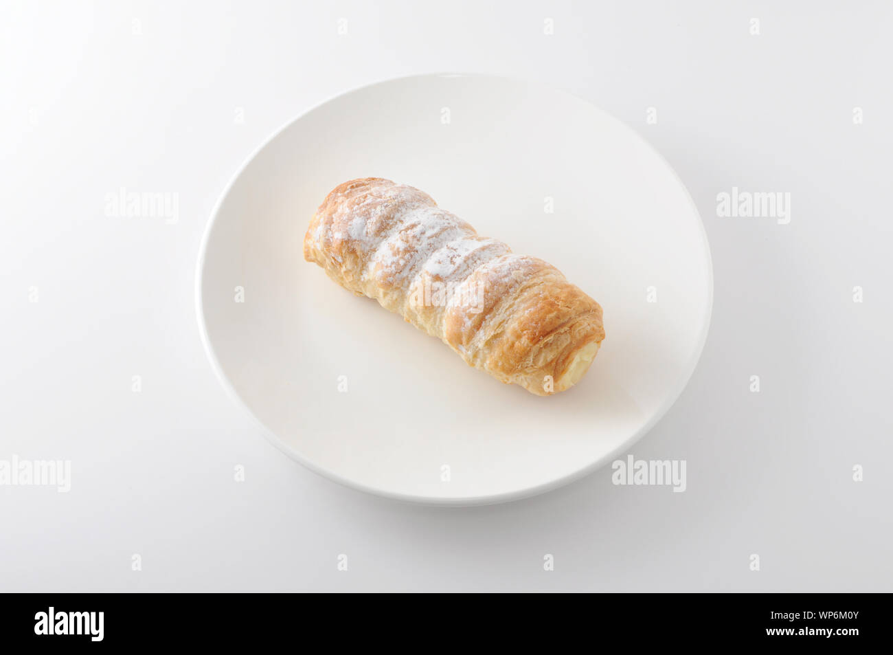 Cannoli cornet with cream pastry closeup isolated on plate on white ...