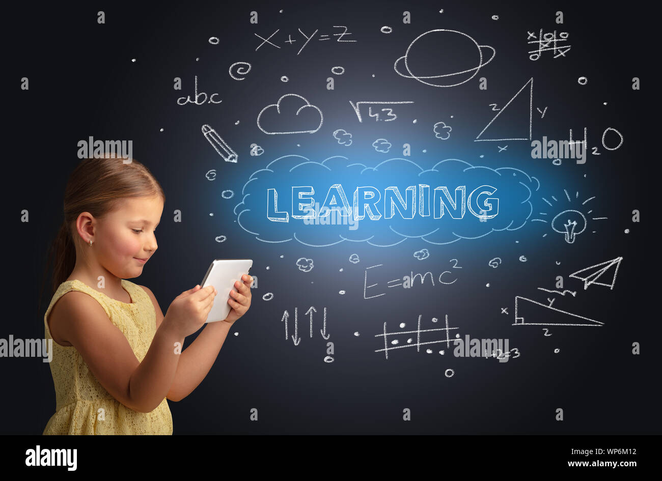 Adorable girl using tablet with educational concept Stock Photo - Alamy