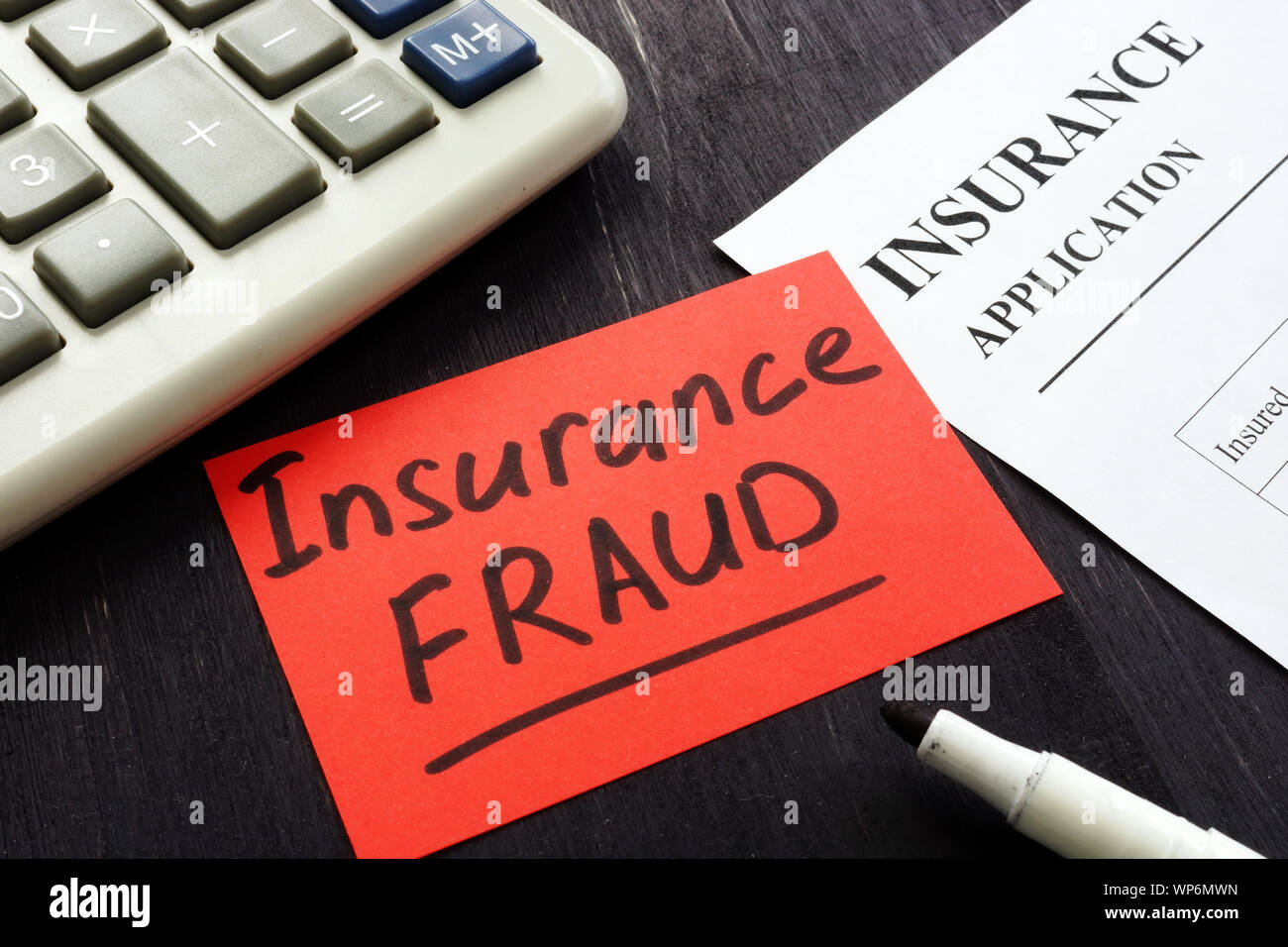 Insurance fraud sign and policy agreement on table Stock Photo - Alamy