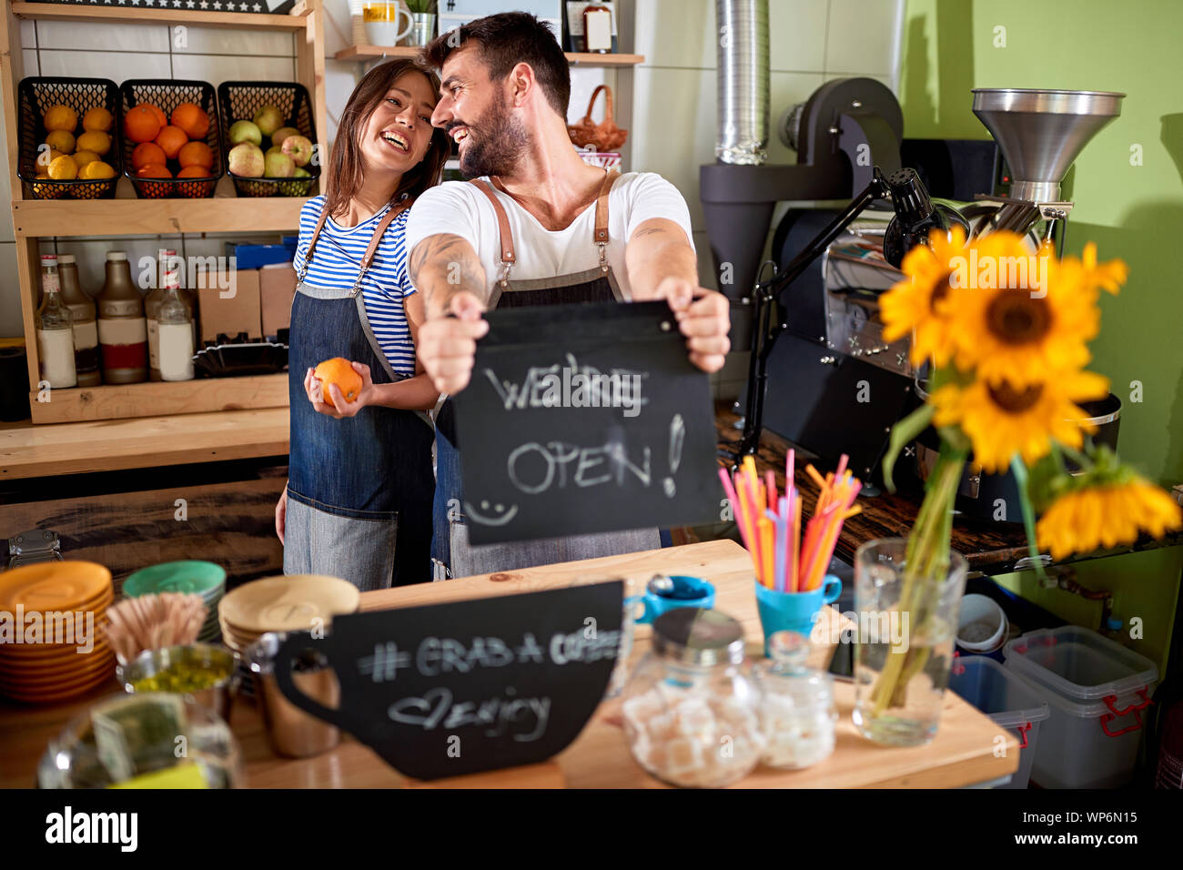Happy owner in their cafe store showing open sign Stock Photo - Alamy