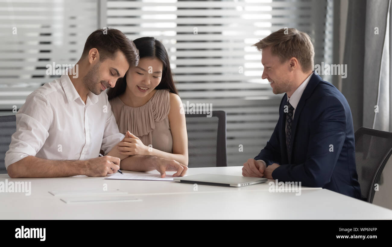 Happy mixed race married spouse signing contract with bank manager ...