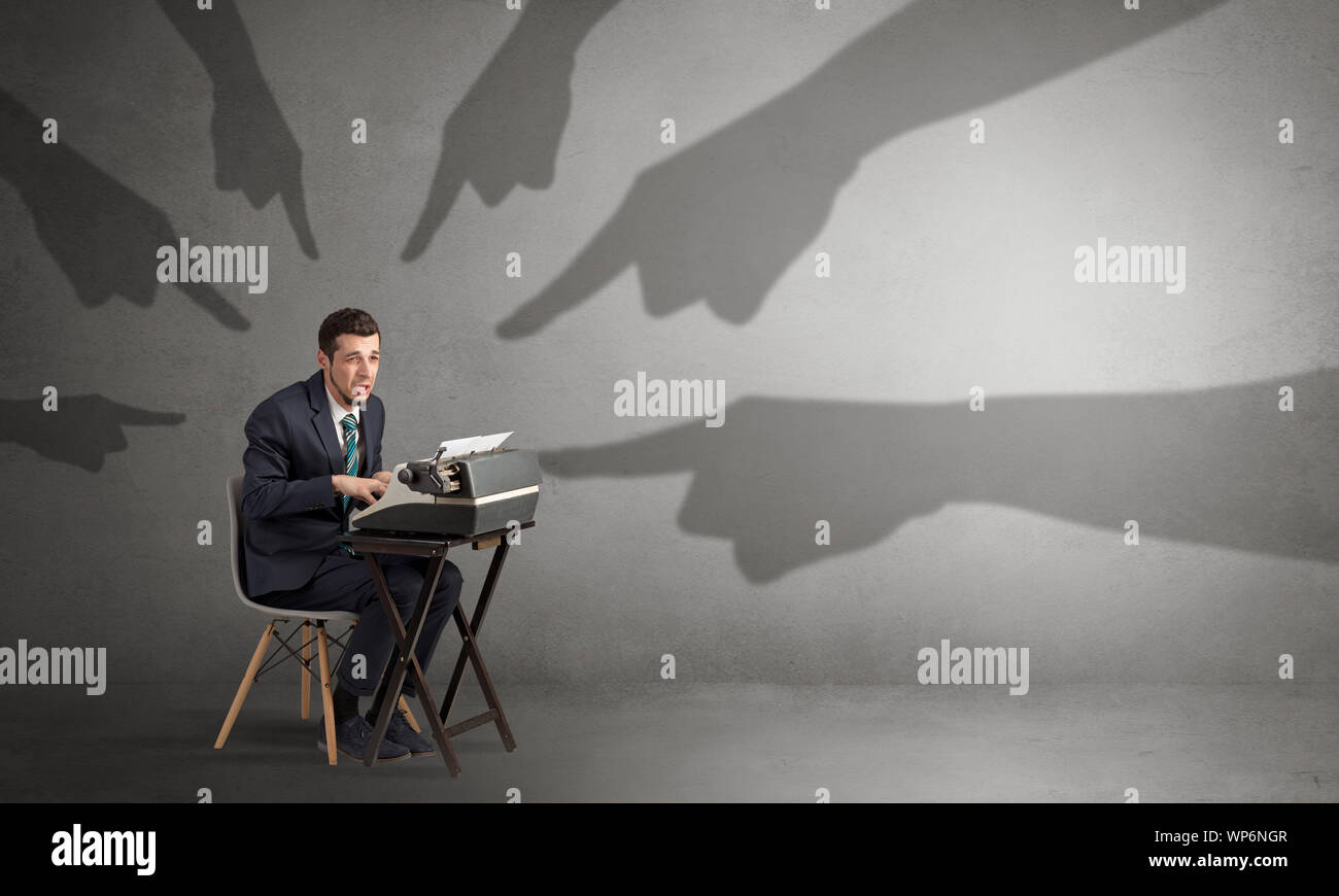 Shadow hand pointing at a small afraid worker Stock Photo - Alamy