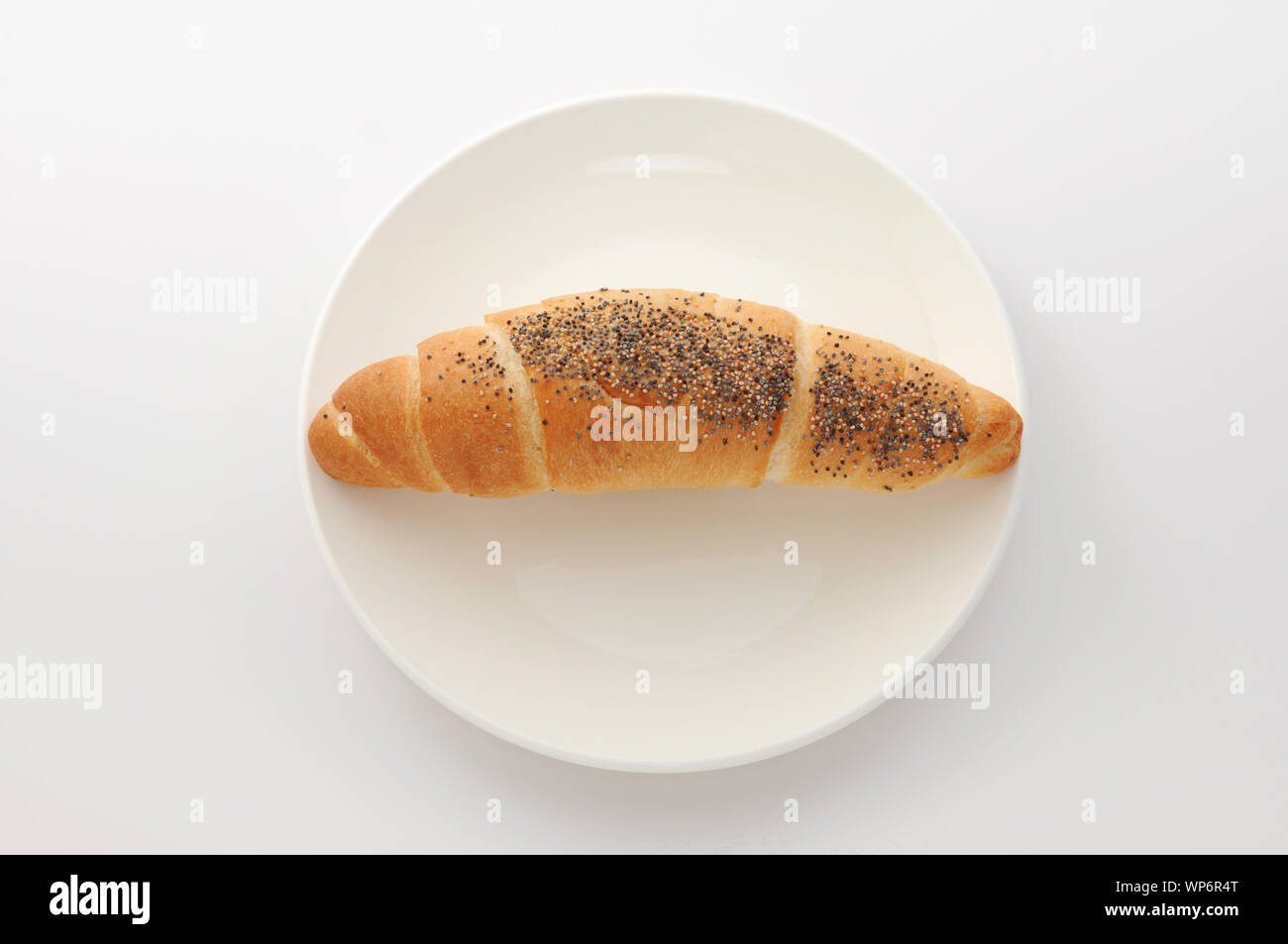 Mini French bread baguette with sesame seeds on plate closeup isolated ...