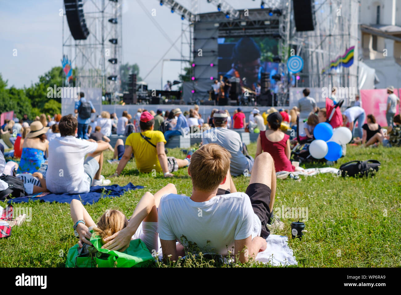 Couple watching concert at open air music festival, back view, stage ...