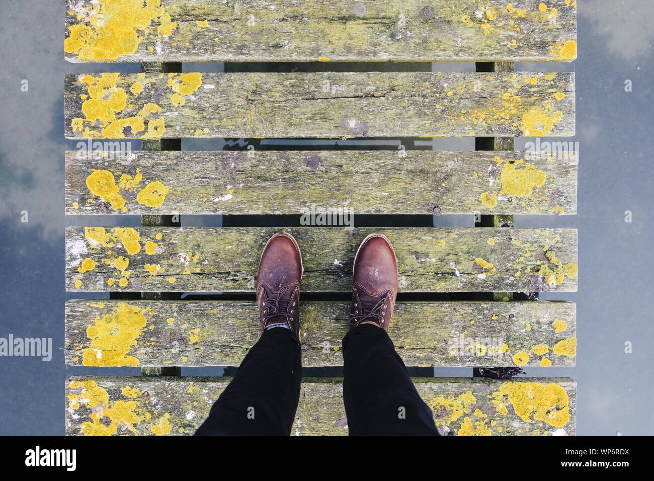 Pair of brown leather shoes standing on an old grey and yellow bridge ...