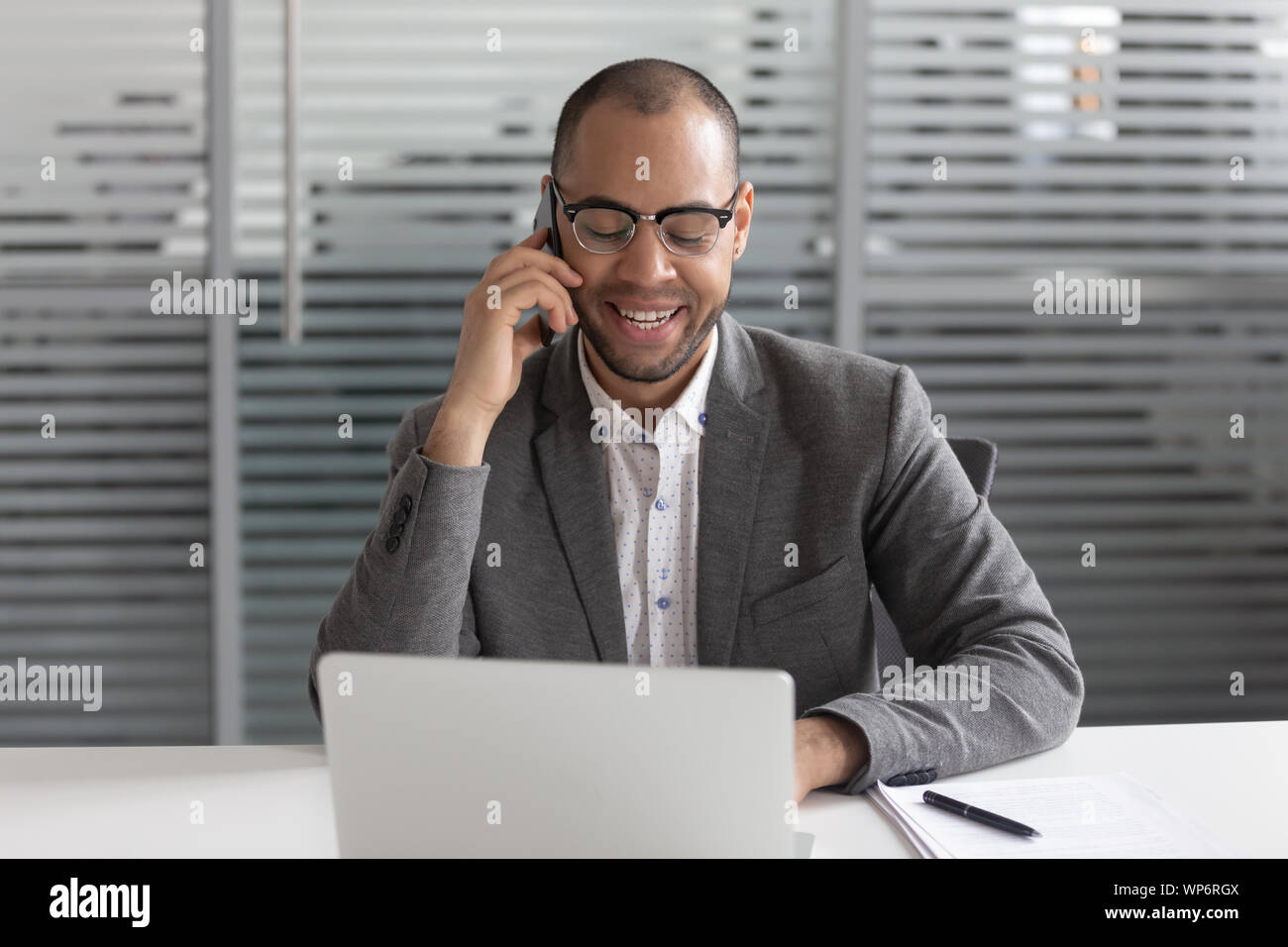 Happy african american businessman talking on cellphone with corporate ...