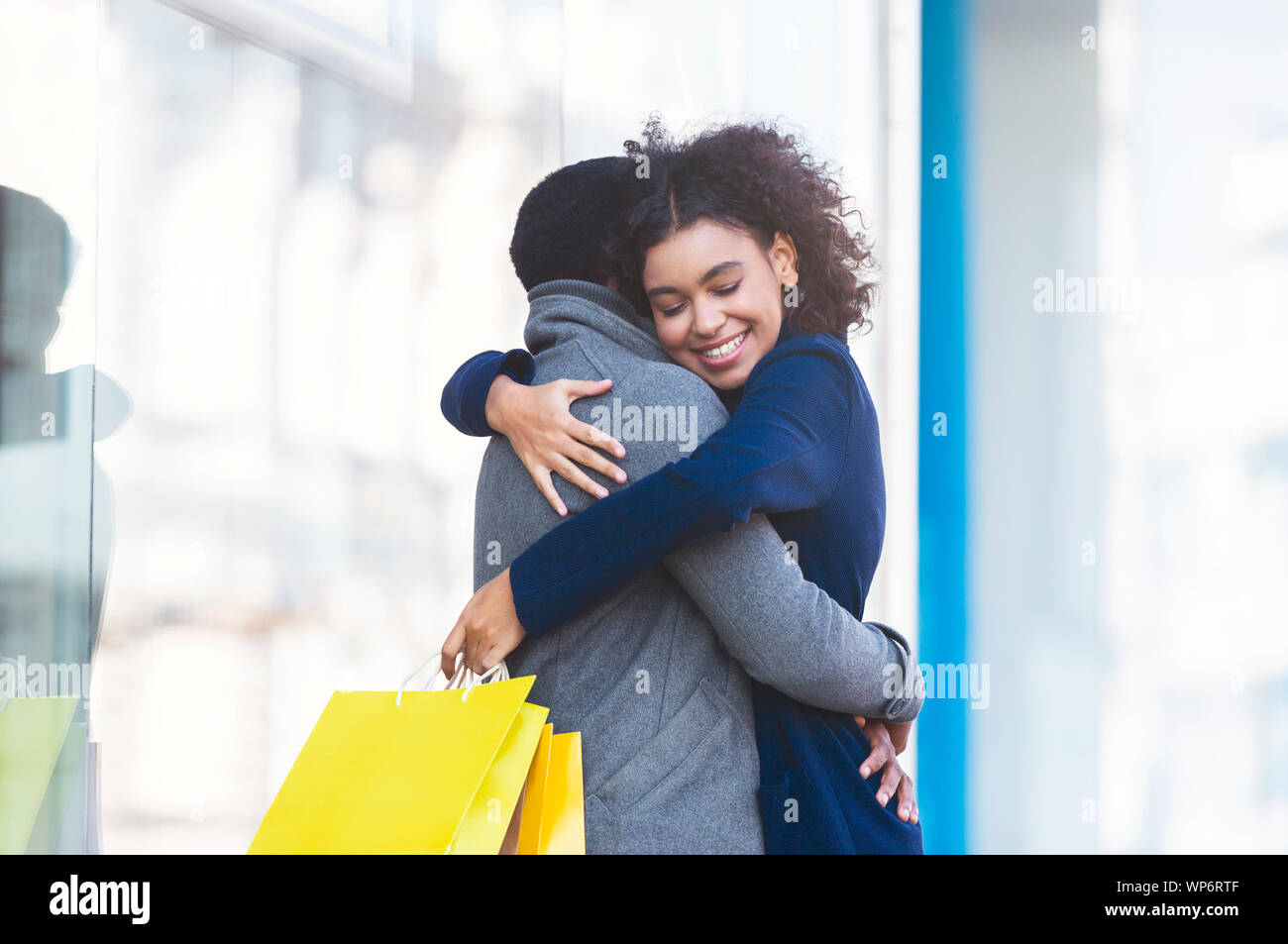Grateful curly girl hugging her boyfriend on the street Stock Photo - Alamy