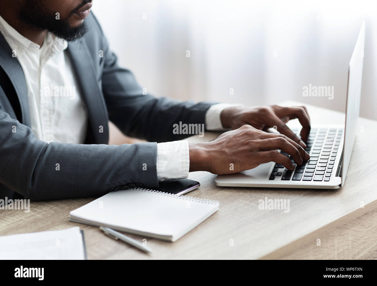 African American employee working on laptop in modern office Stock ...
