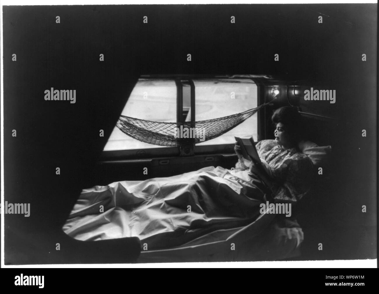 Lady reading in berth [with the] curtains up Stock Photo - Alamy