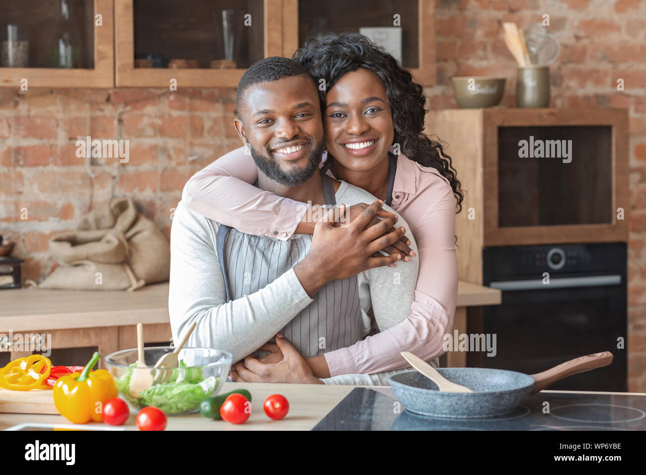 Grateful african woman hugging her husband at kitchen Stock Photo - Alamy