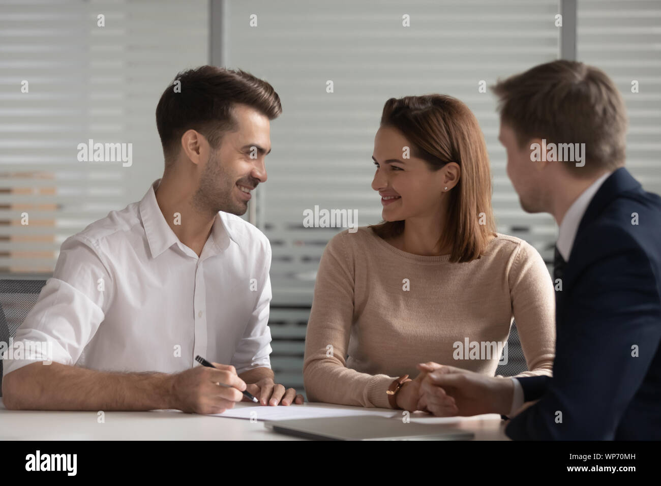 Young happy married family couple making decision before signing ...