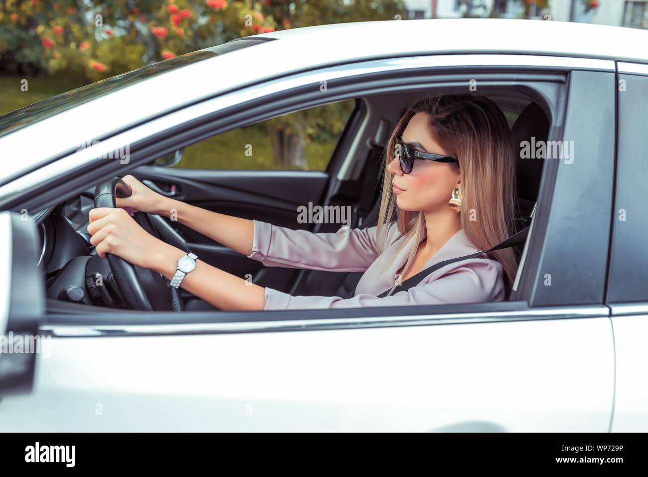 Beautiful business woman lady driving a car in sunglasses, in the ...