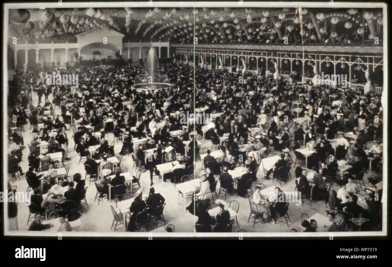 Large banquet hall filled with people at tables, fountain in center ...