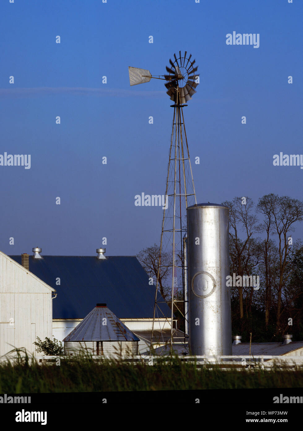 Large windmill and modern feed silo on an American farm Stock Photo - Alamy