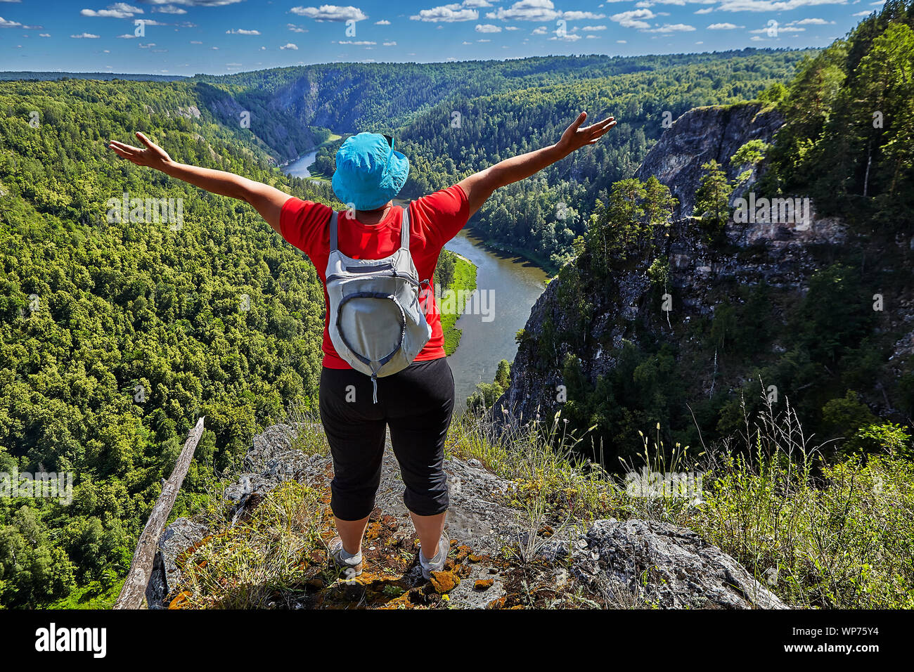 An overweight woman rejoices that she was able to climb a mountain peak ...