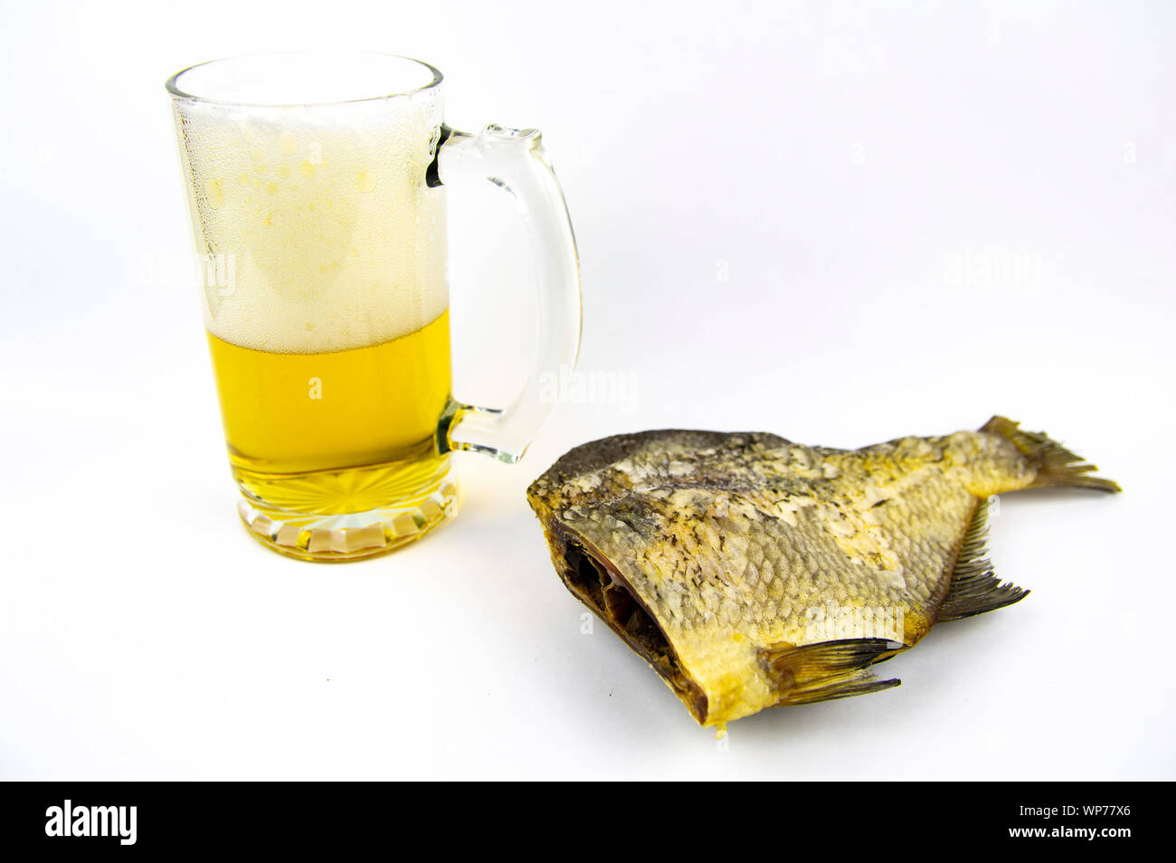 Dried fish and beer in a glass isolated on white background. Fishing ...