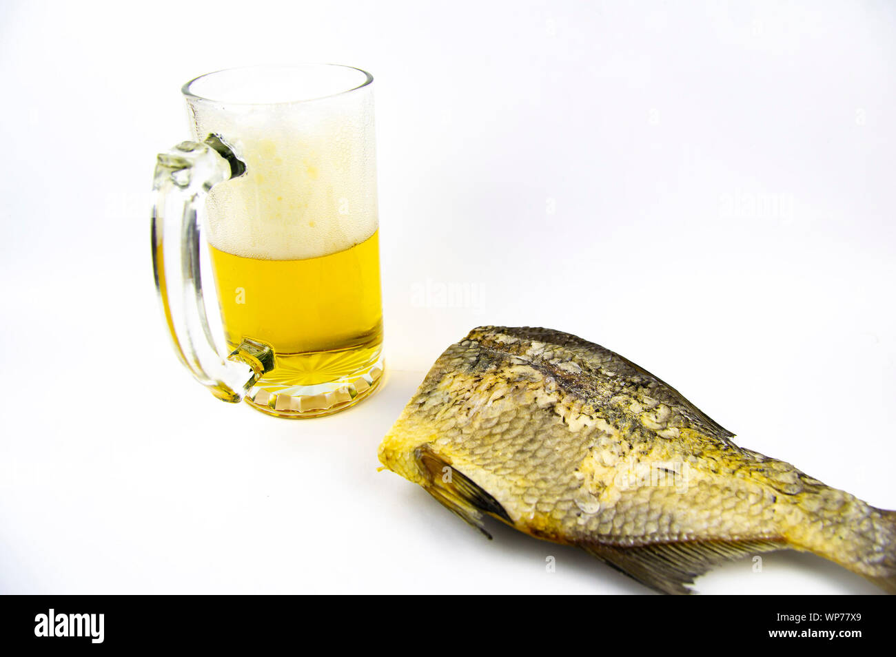 Dried fish and beer in a glass isolated on white background. Fishing ...